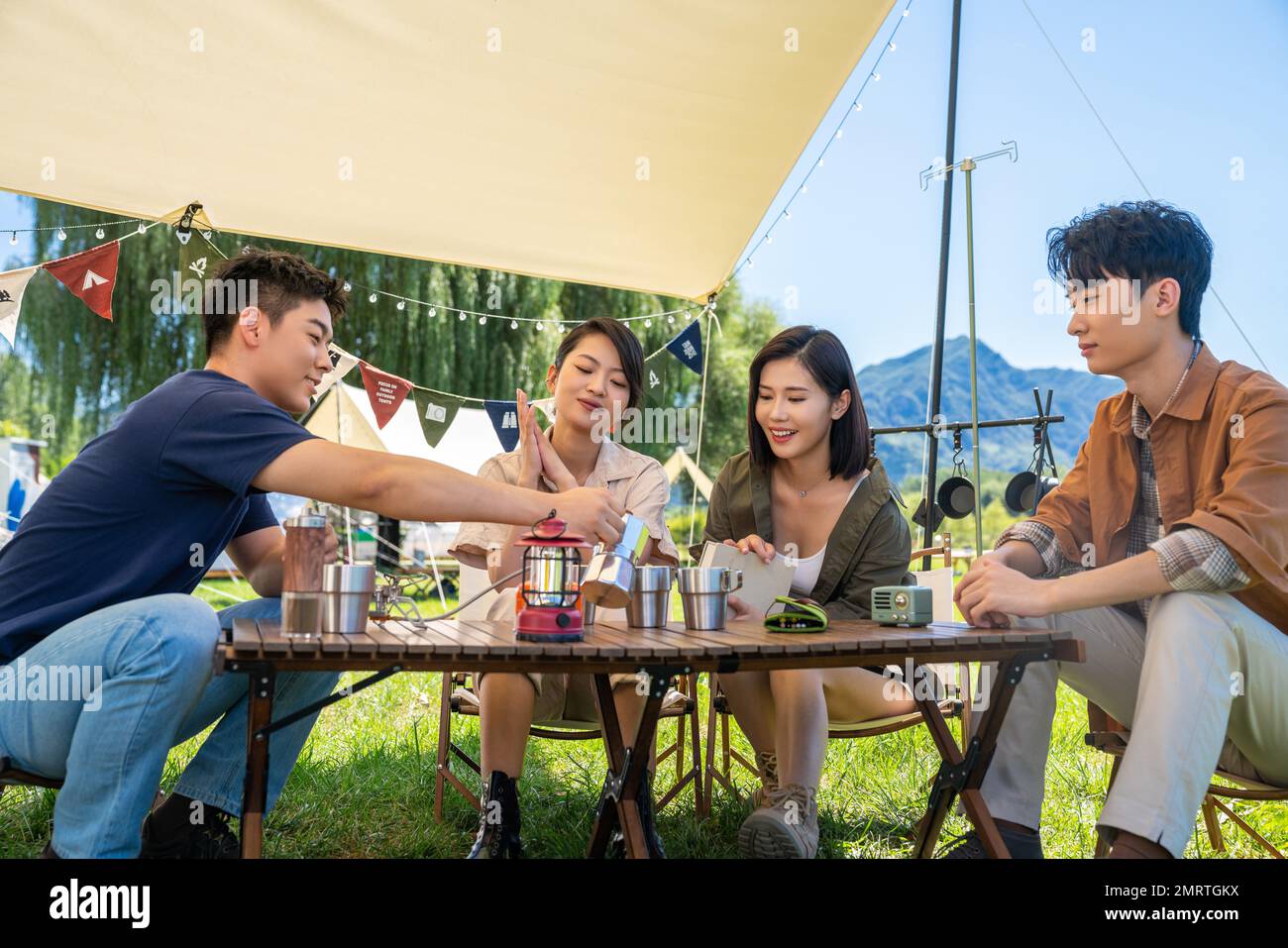 A group of people sat under the awning to drink coffee Stock Photo - Alamy