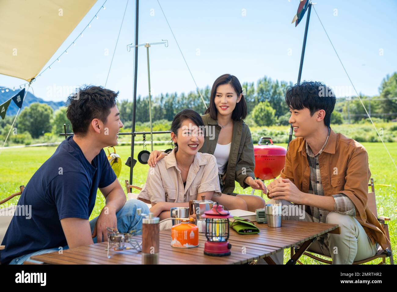 A group of people sat under the awning to drink coffee Stock Photo - Alamy