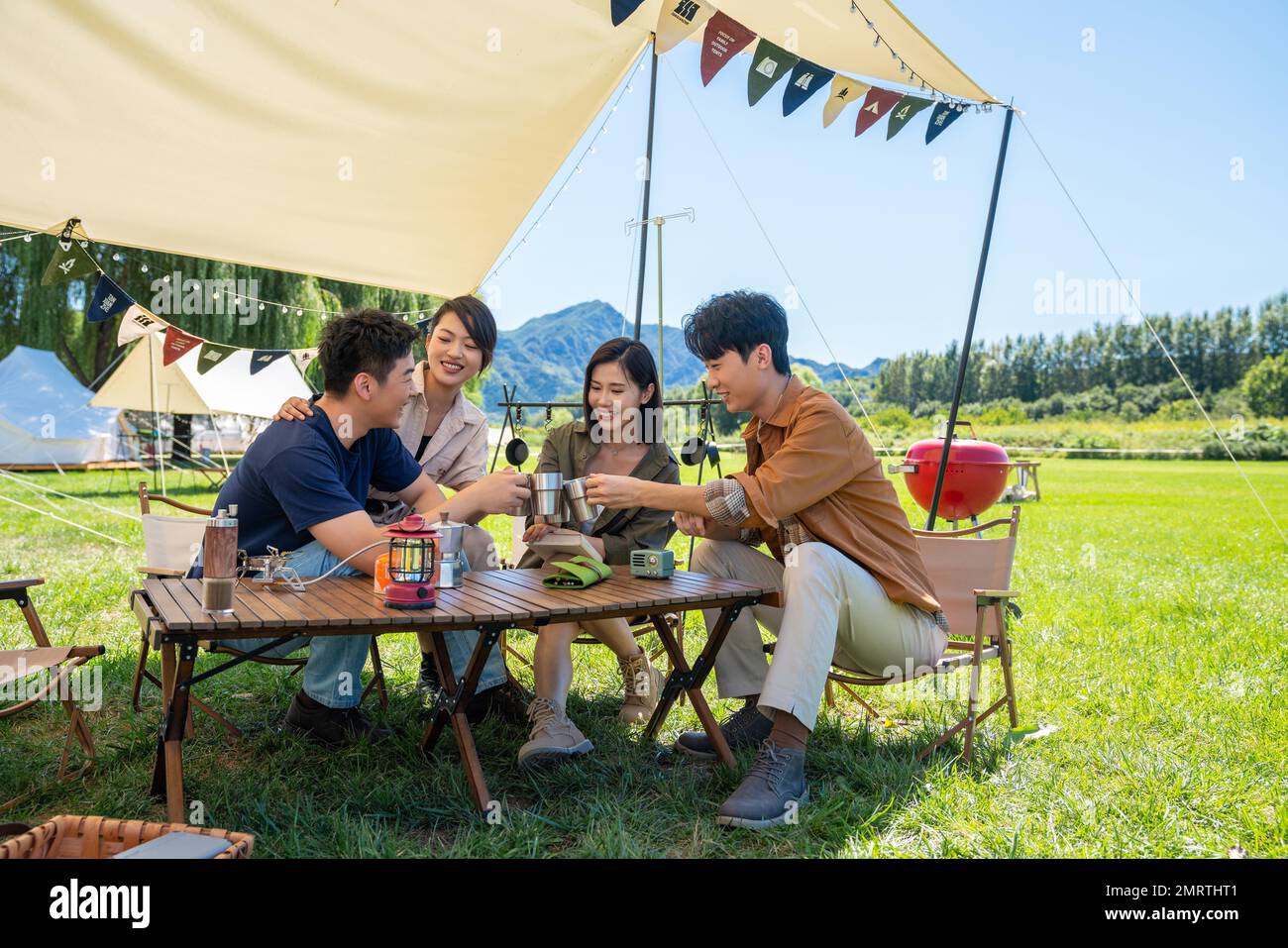 A group of people sat under the awning to drink coffee Stock Photo - Alamy