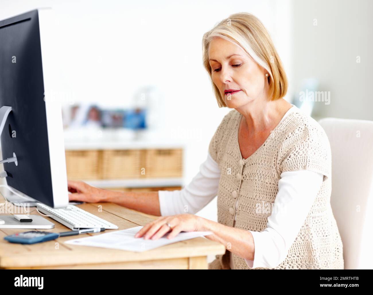 Senior woman calculating monthly expenses using computer. Portrait of a ...