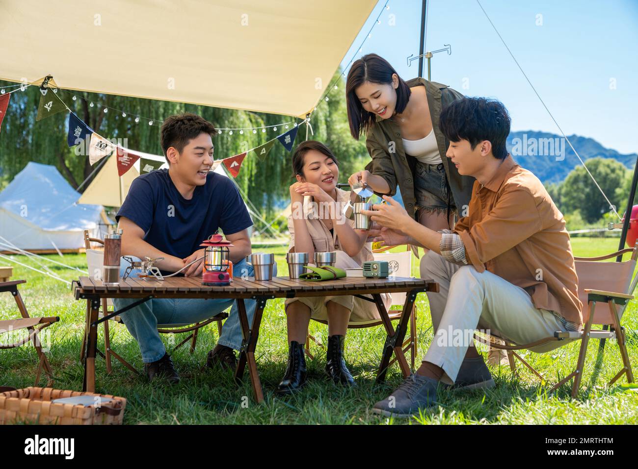 A group of people sat under the awning to drink coffee Stock Photo - Alamy