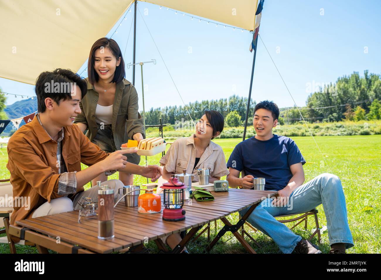 A group of people sat under the awning to drink coffee Stock Photo - Alamy