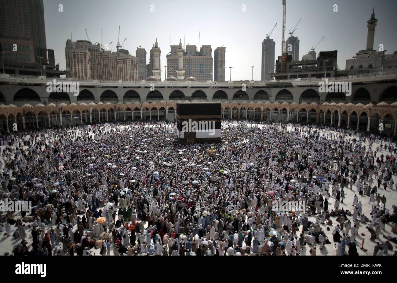 Muslim pilgrims circumambulate around the Kaaba, the cubic building at ...