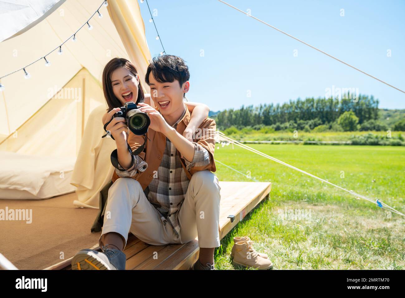 Couples sit under tents see camera Stock Photo - Alamy