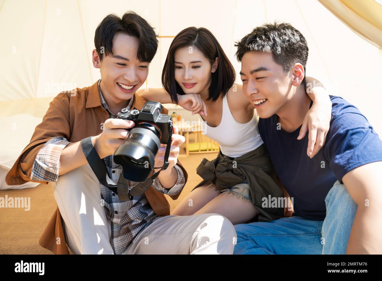 A group of people sit under the tent see camera Stock Photo - Alamy