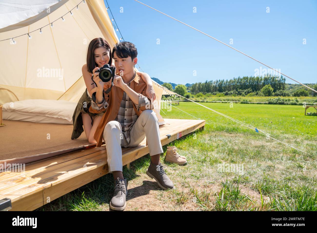Couples sit under tents see camera Stock Photo - Alamy
