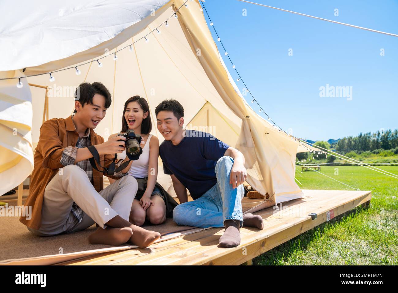 A group of people sit under the tent see camera Stock Photo - Alamy