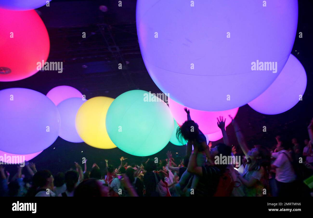 Visitors reach out for colorful balloons "Sound Spheres" as they enjoy ...
