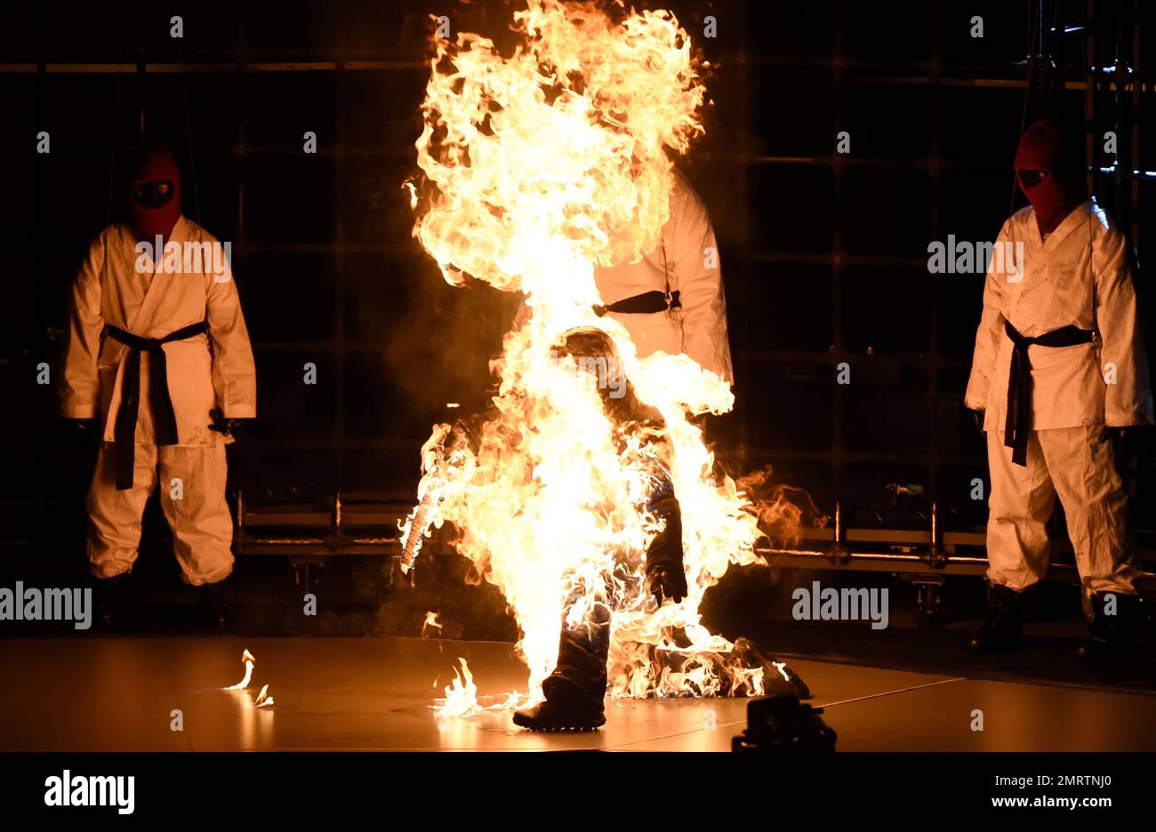 A dancer appears on stage on fire as Kendrick Lamar performs a medley ...