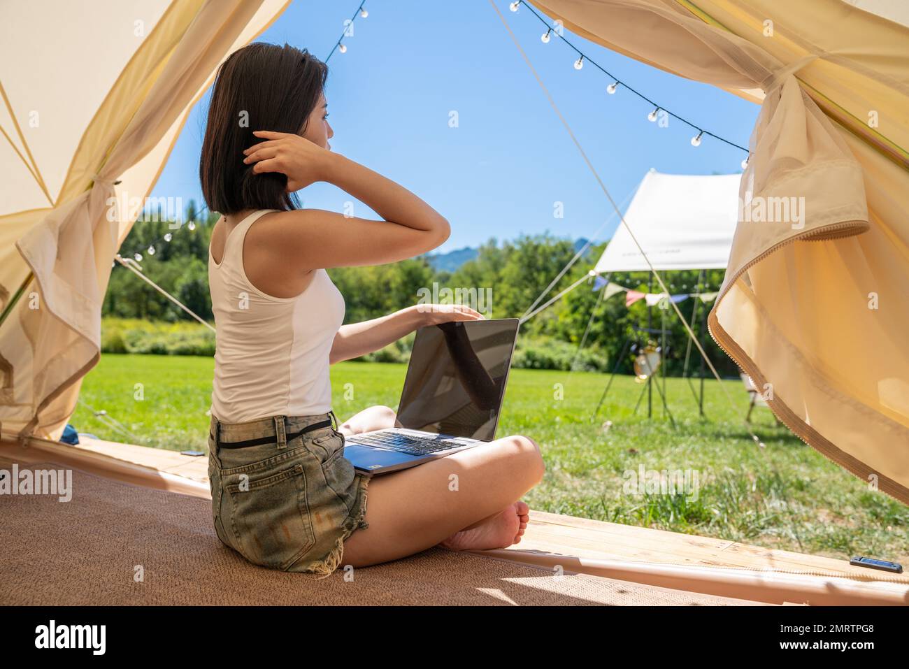 The girl sat tent to use a computer Stock Photo - Alamy