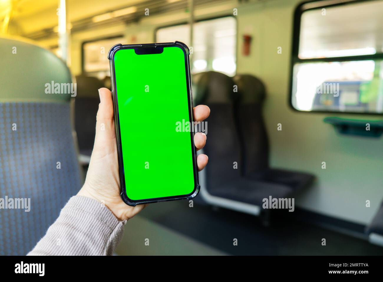 Female hand holding chroma key screen phone in the train. Social ...