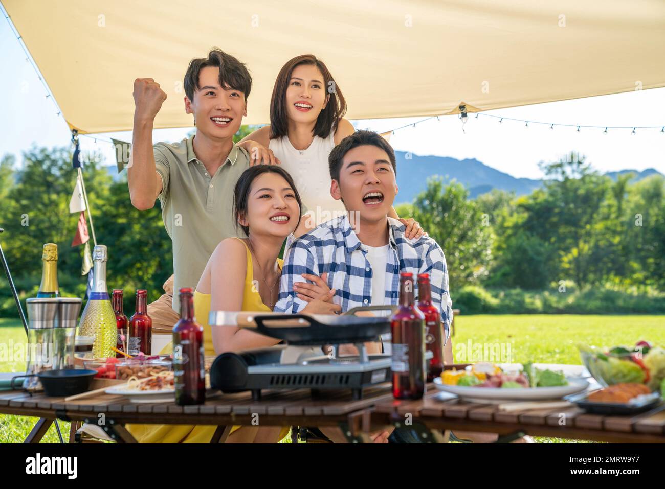 A group of people sat under the awning Stock Photo - Alamy