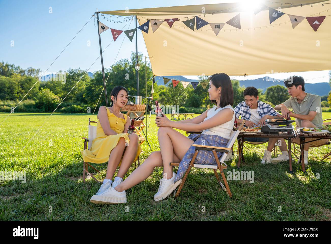 A group of people sat under the awning Stock Photo - Alamy
