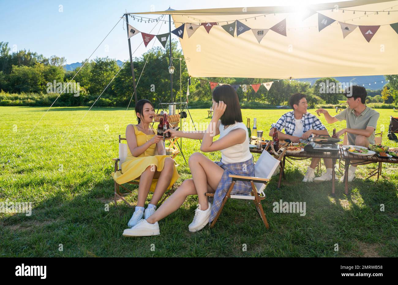 A group of people sat under the awning Stock Photo - Alamy