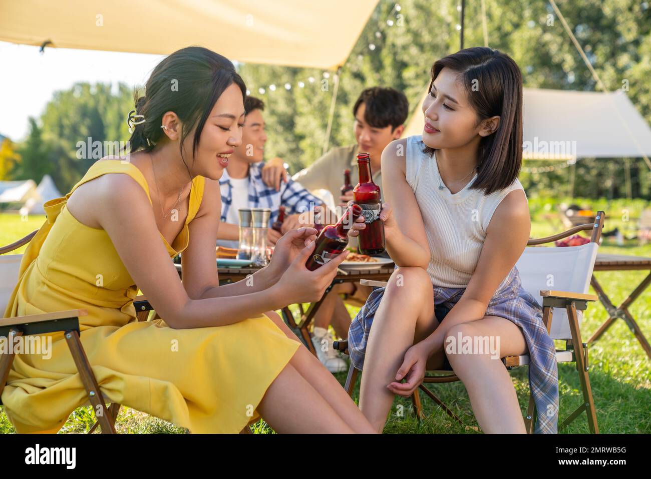 A group of people sat under the awning Stock Photo - Alamy