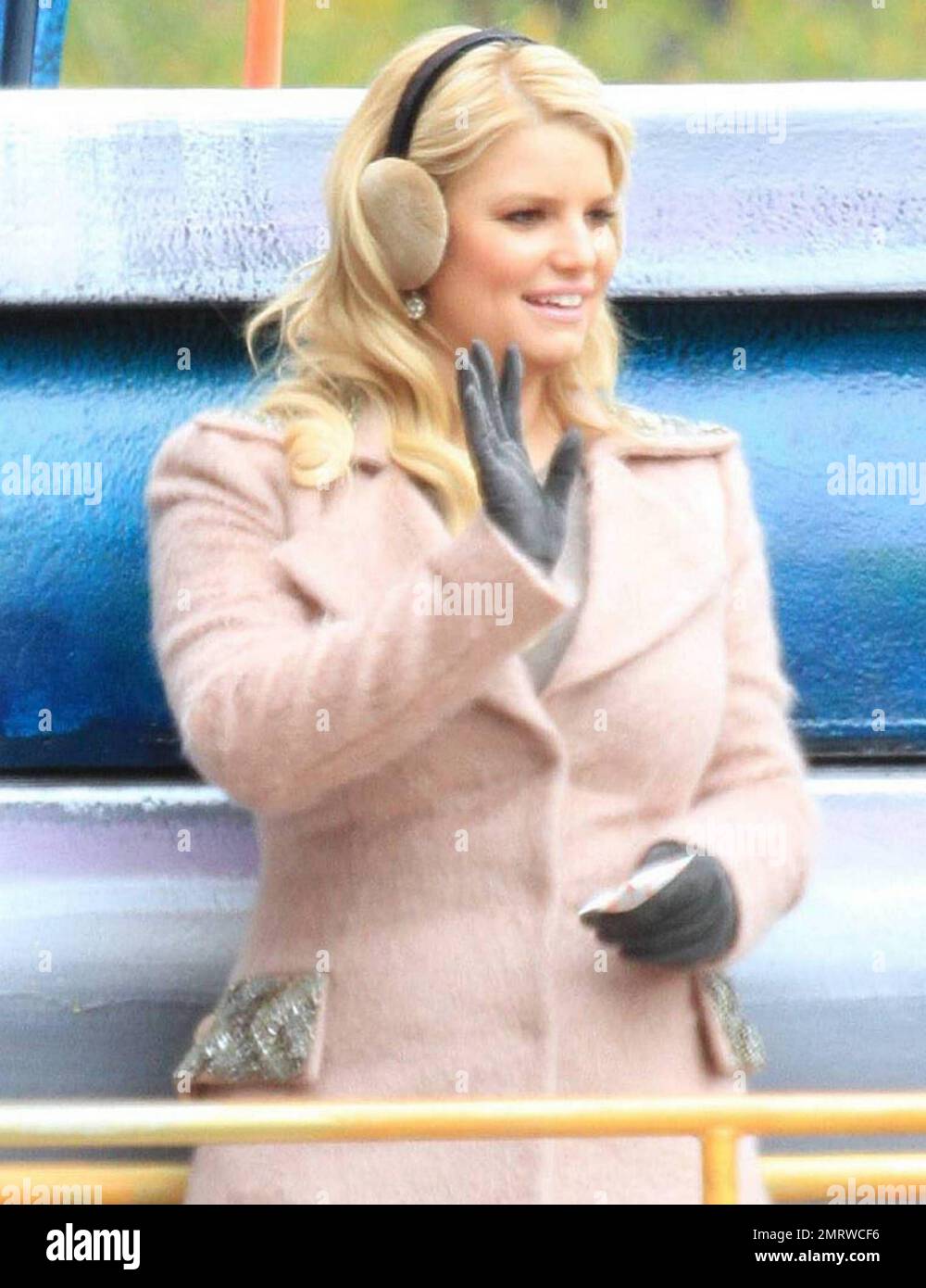 Wearing a pretty pink wool jacket, earmuffs and skintight boots ...