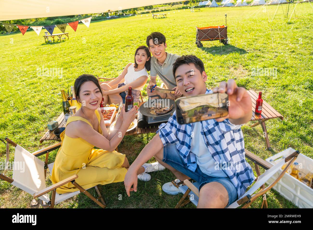 A group of people sat under the awning Stock Photo - Alamy