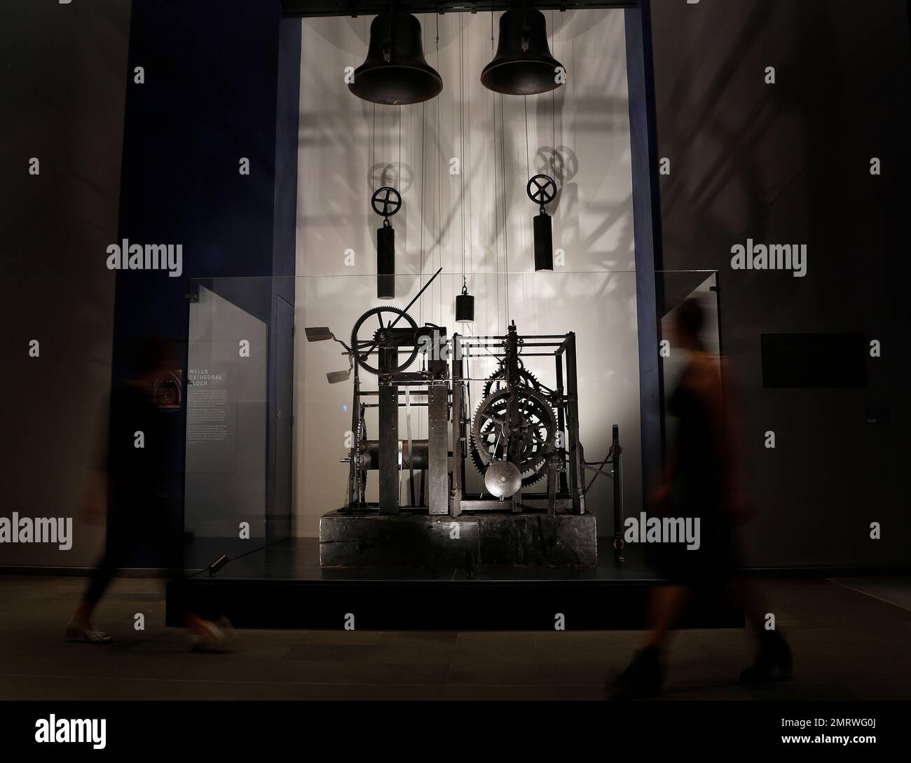 People walk past the Wells Cathedral clock mechanism, on display at the ...