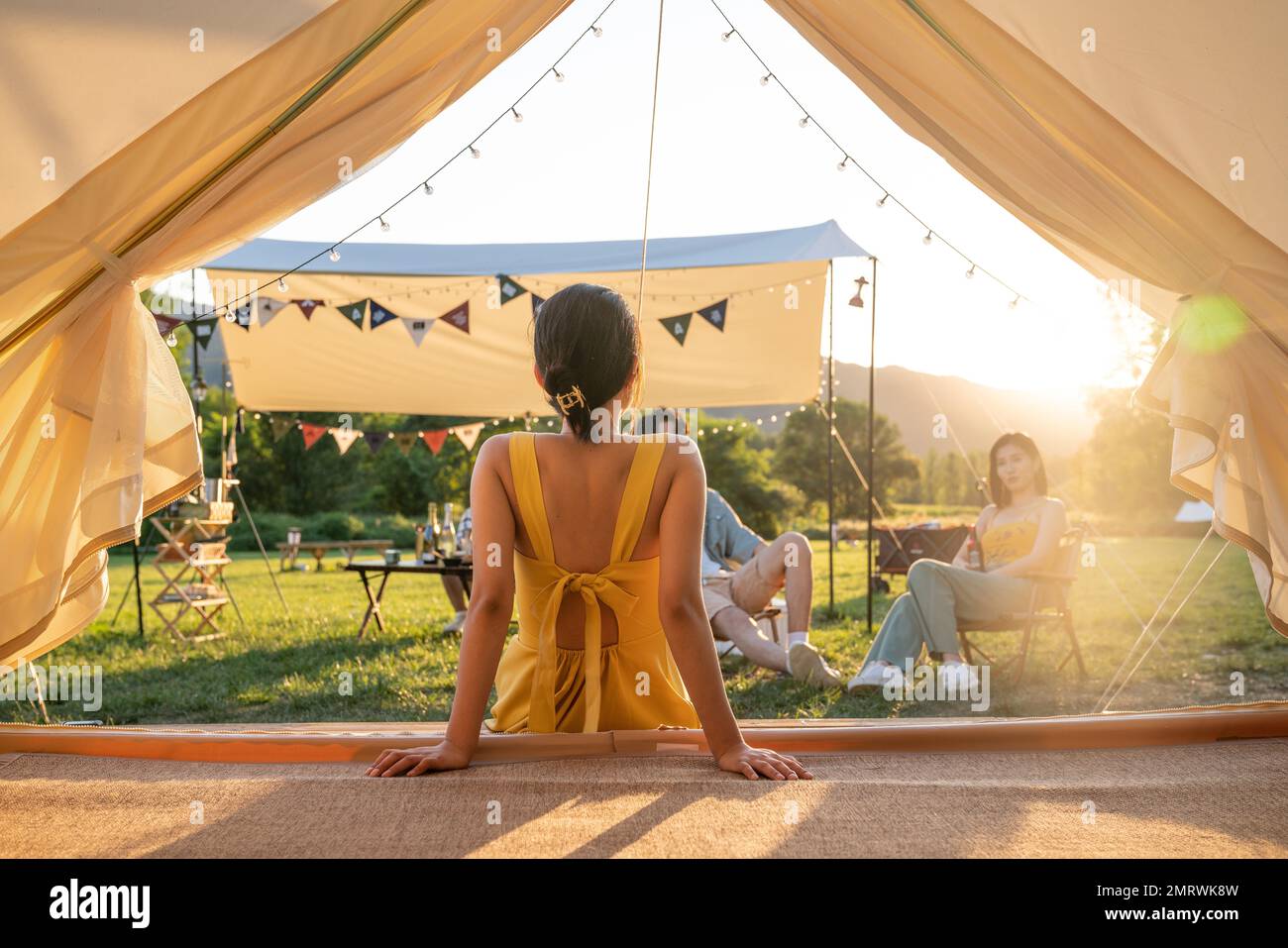 A group of people sat under the tent Stock Photo - Alamy