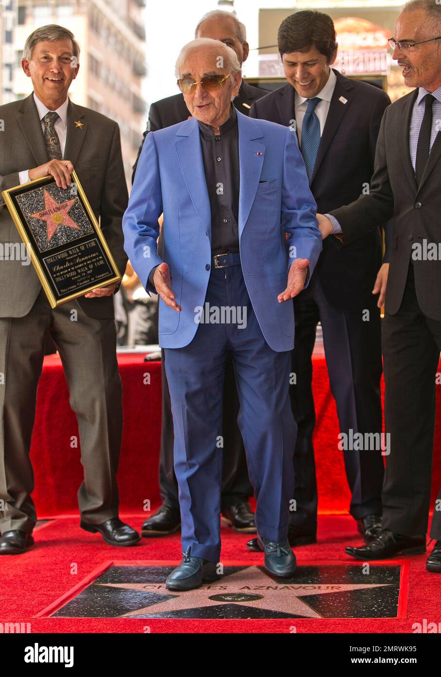 Singer and songwriter Charles Aznavour, center, steps on his star as he ...
