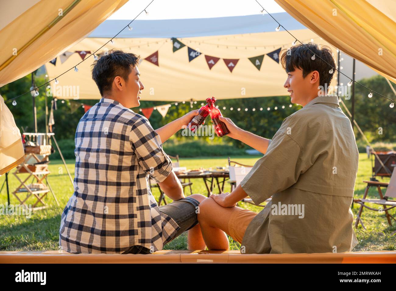 A group of people sat under the tent Stock Photo - Alamy