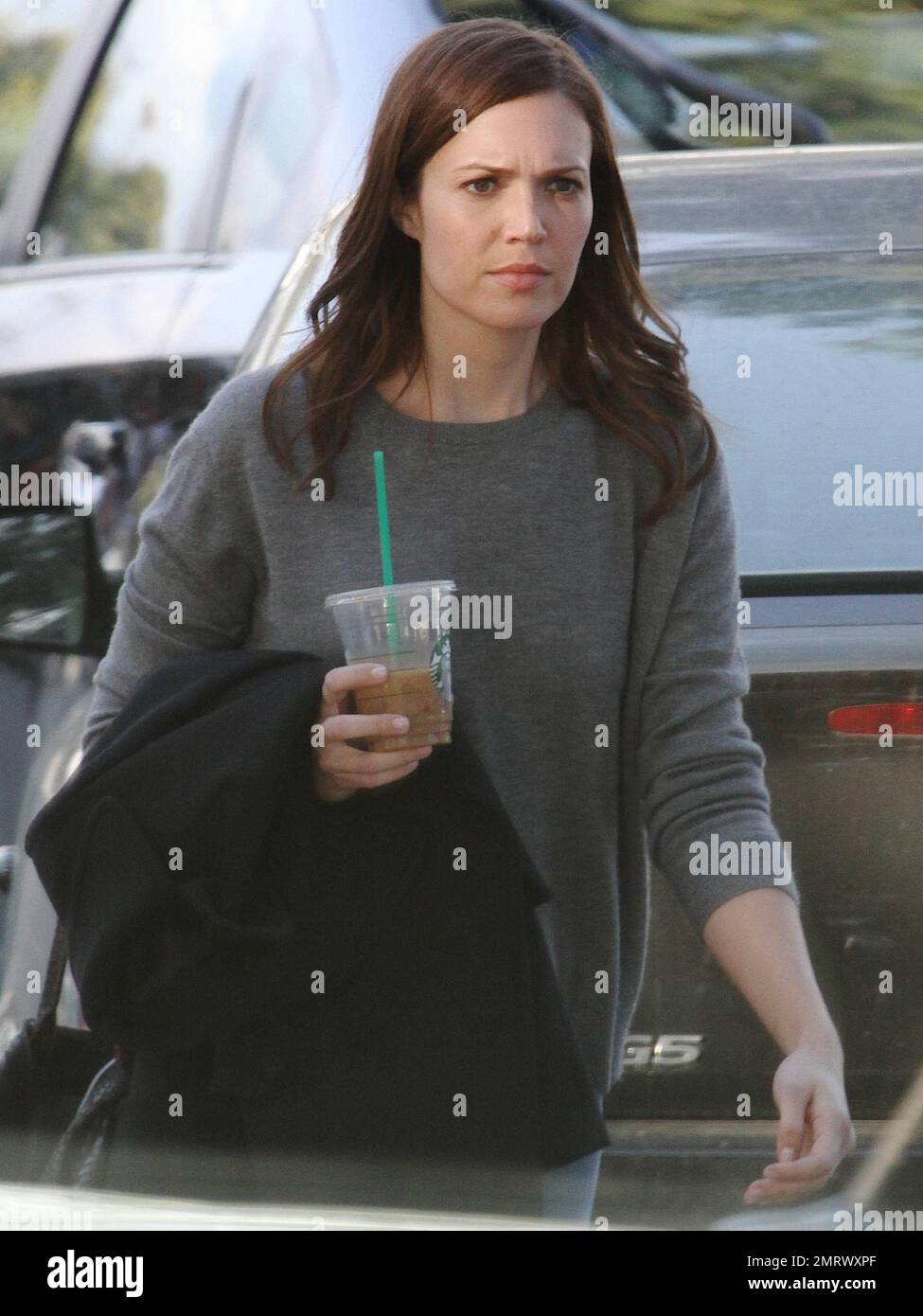 EXCLUSIVE!! Wearing a grey sweater and sipping a drink from Starbucks ...