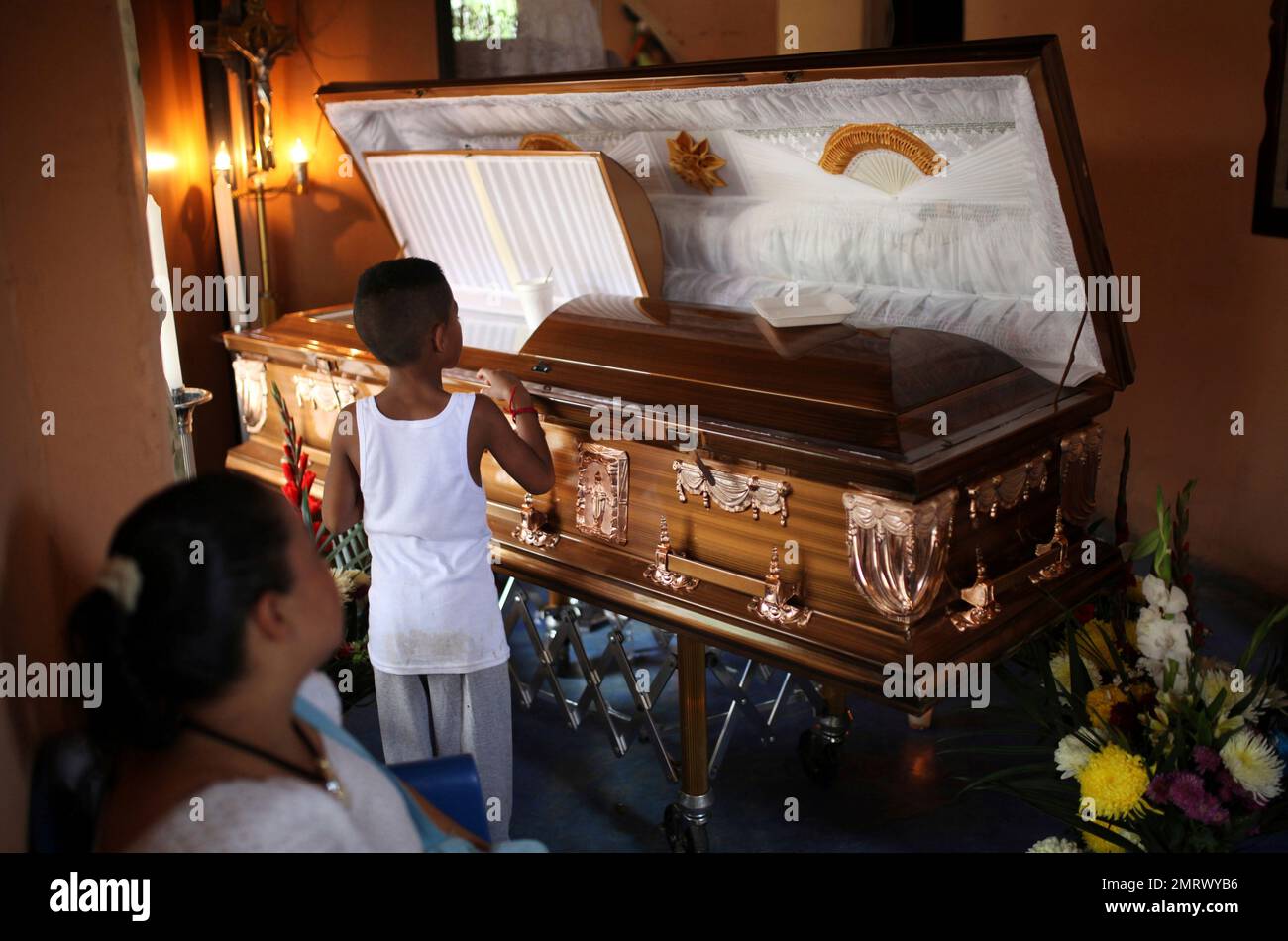 A boy looks at the coffin holding the body of Candido Rios Vazquez, a ...