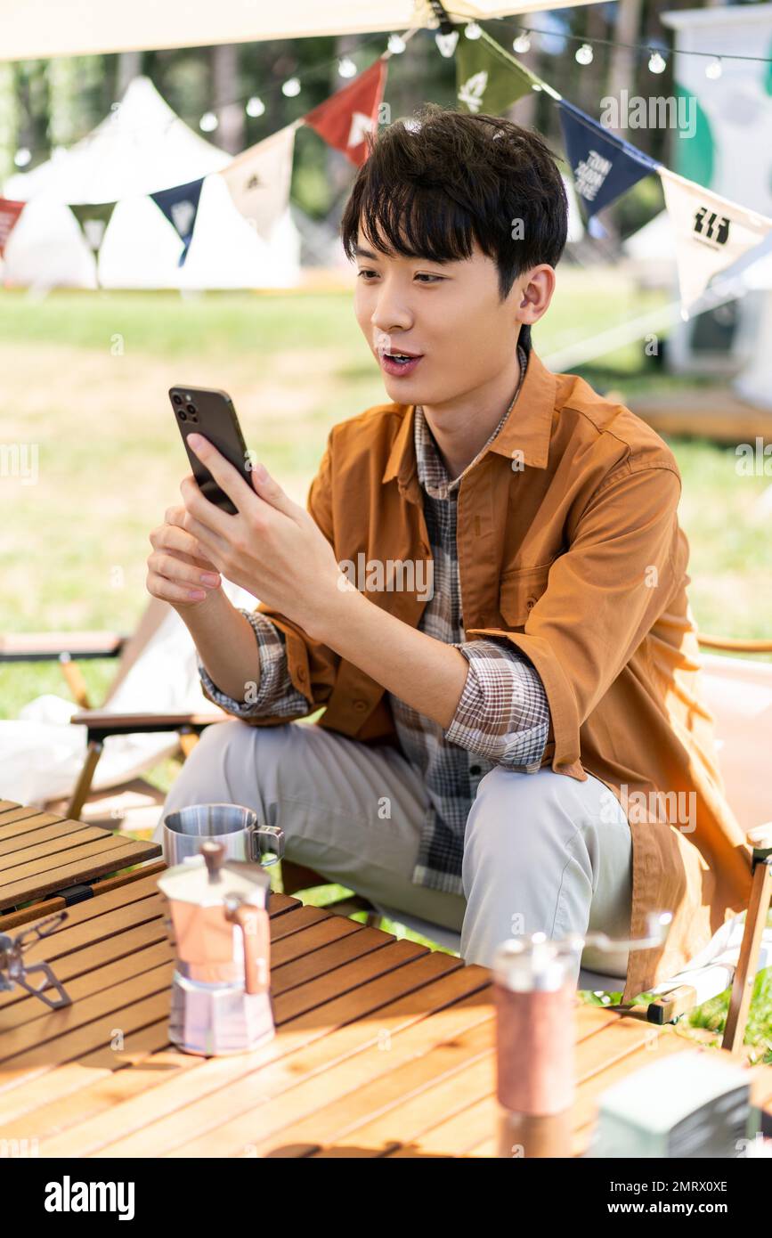 The boy sitting under the awning cell phone video Stock Photo - Alamy
