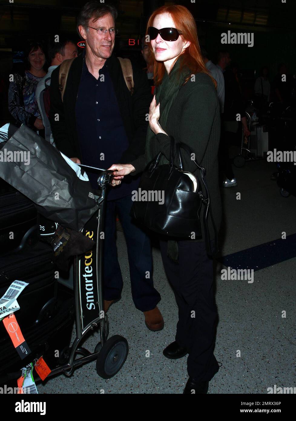 Marcia Cross' husband Tom Mahoney walks with his arm around her as the ...