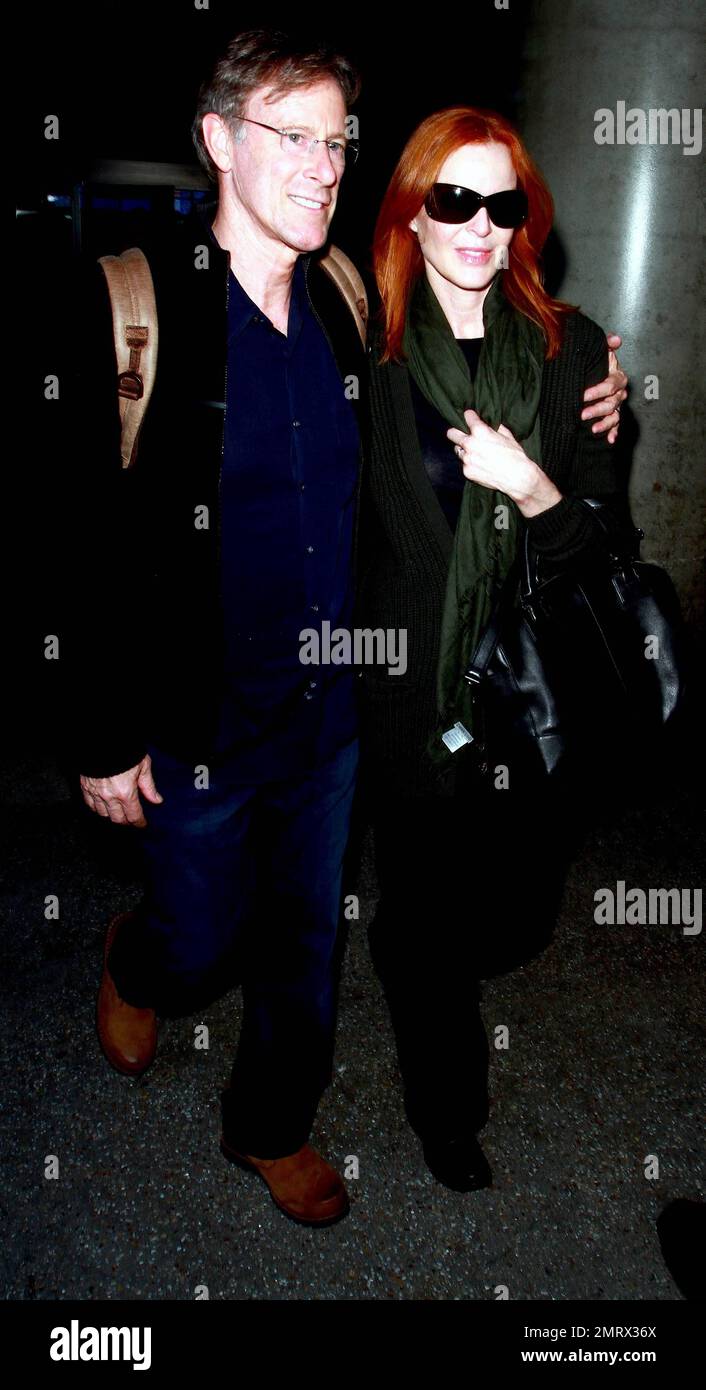 Marcia Cross' husband Tom Mahoney walks with his arm around her as the ...
