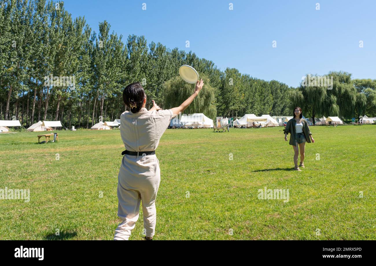 Two people at the campsite play frisbee Stock Photo - Alamy