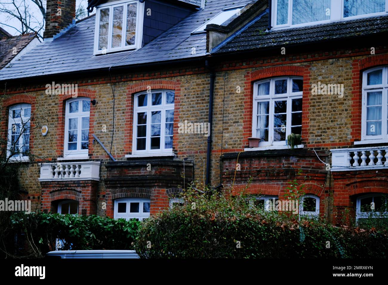 A two-story brick building with bushes in front Stock Photo - Alamy
