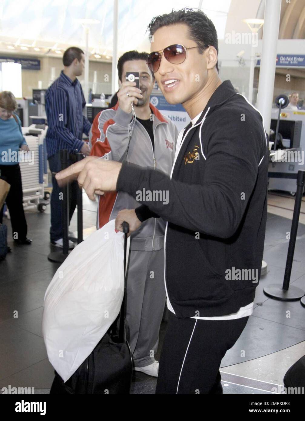 Mario Lopez heads through the line at a security checkpoint inside LAX ...