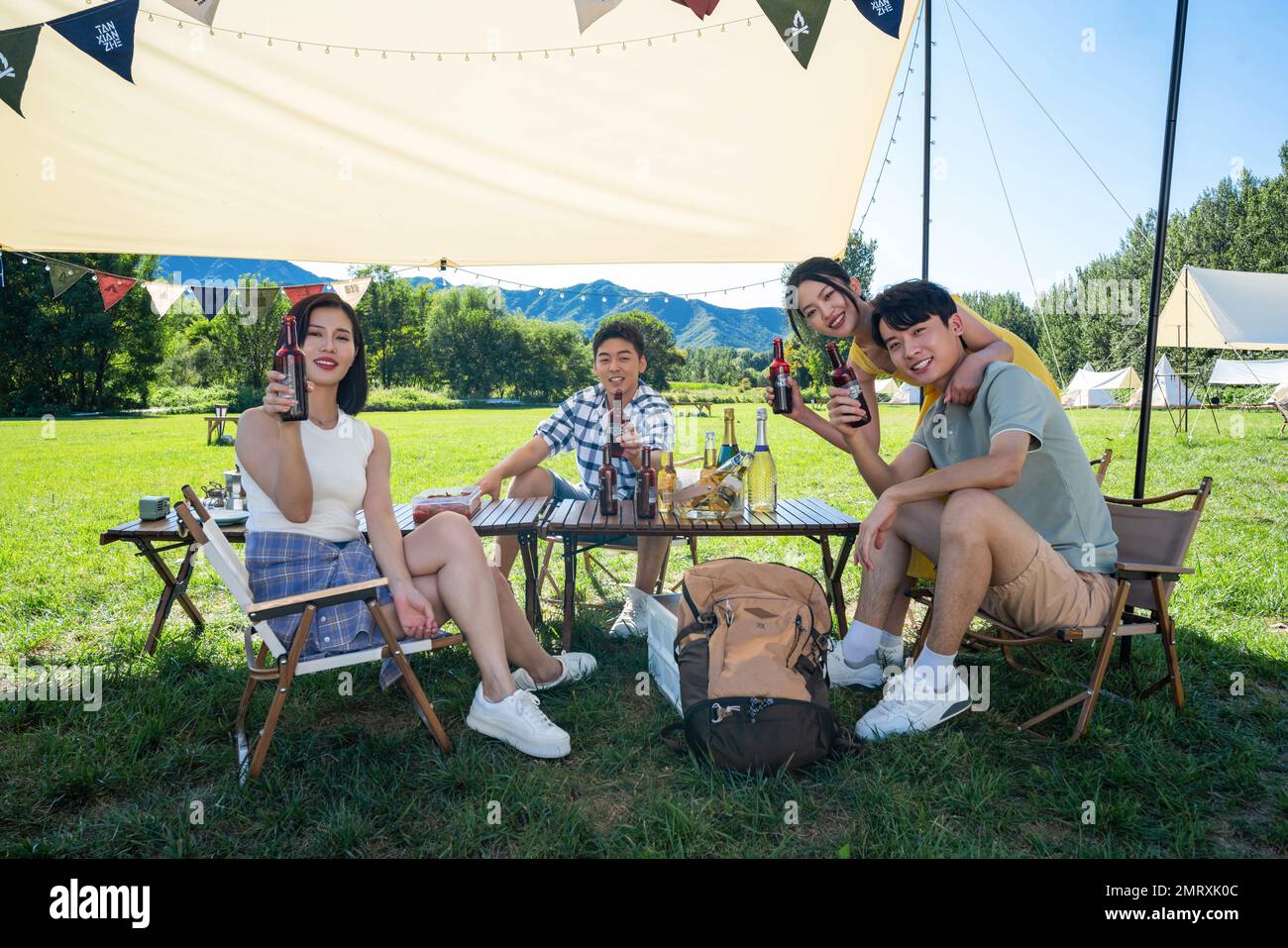 A group of people sat under the awning Stock Photo - Alamy