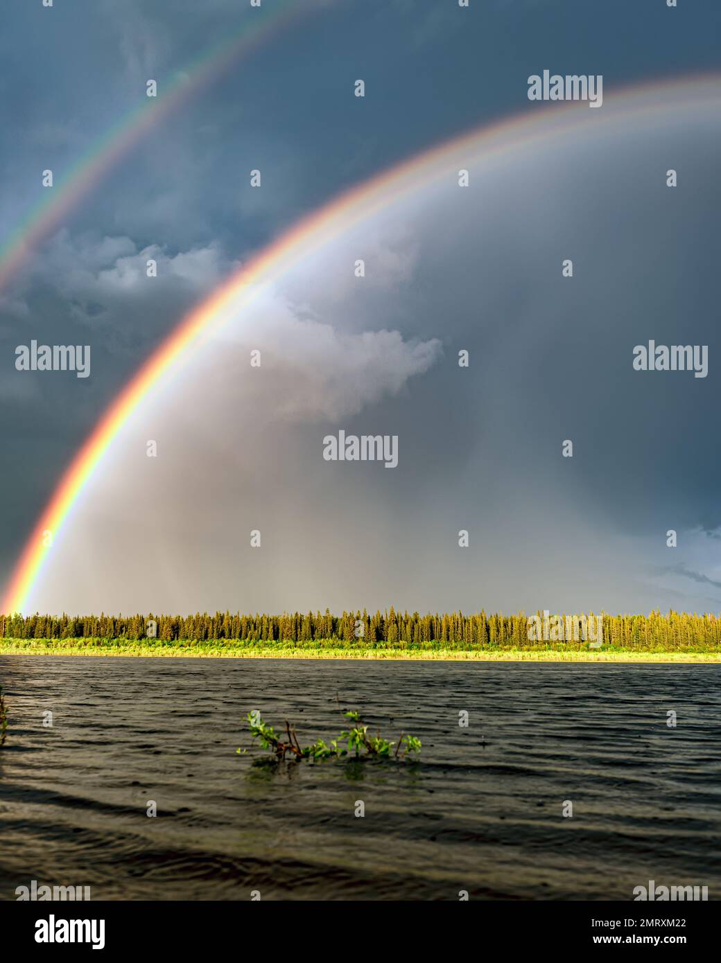 Double rainbow over the Vilyui River with raindrops against a blue sky ...