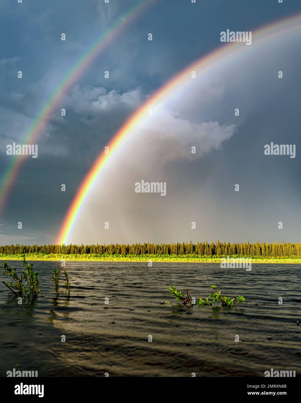 A double rainbow over the Vilyui River with raindrops against a blue ...