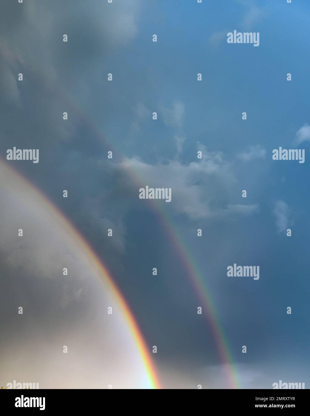 Double rainbow over the Vilyui River with raindrops against a blue sky ...