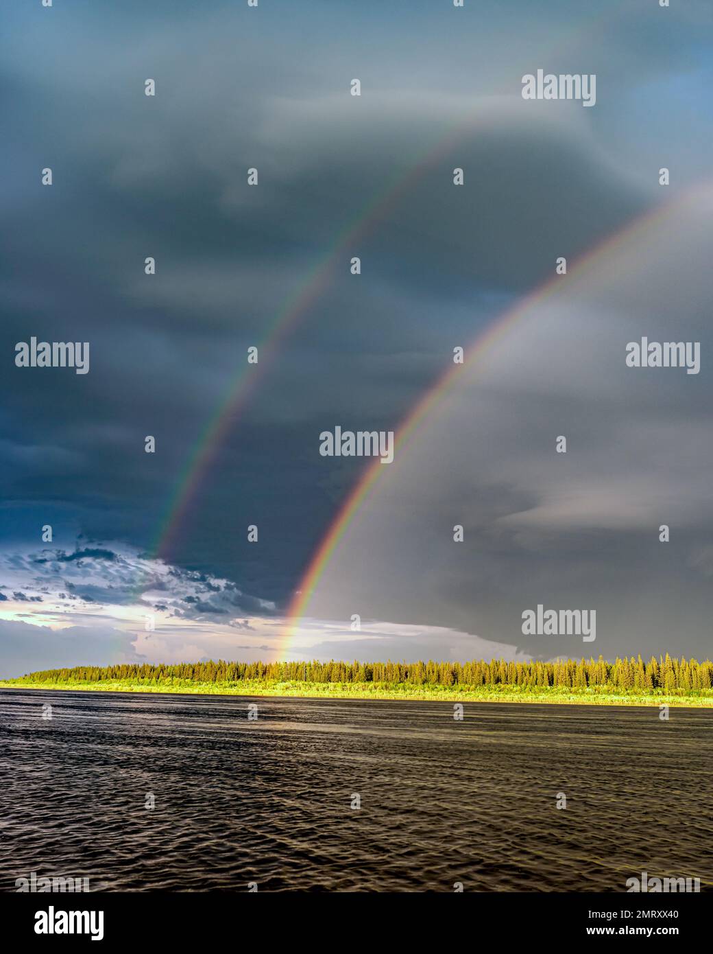 Double rainbow over the Vilyui River with raindrops against a blue sky ...