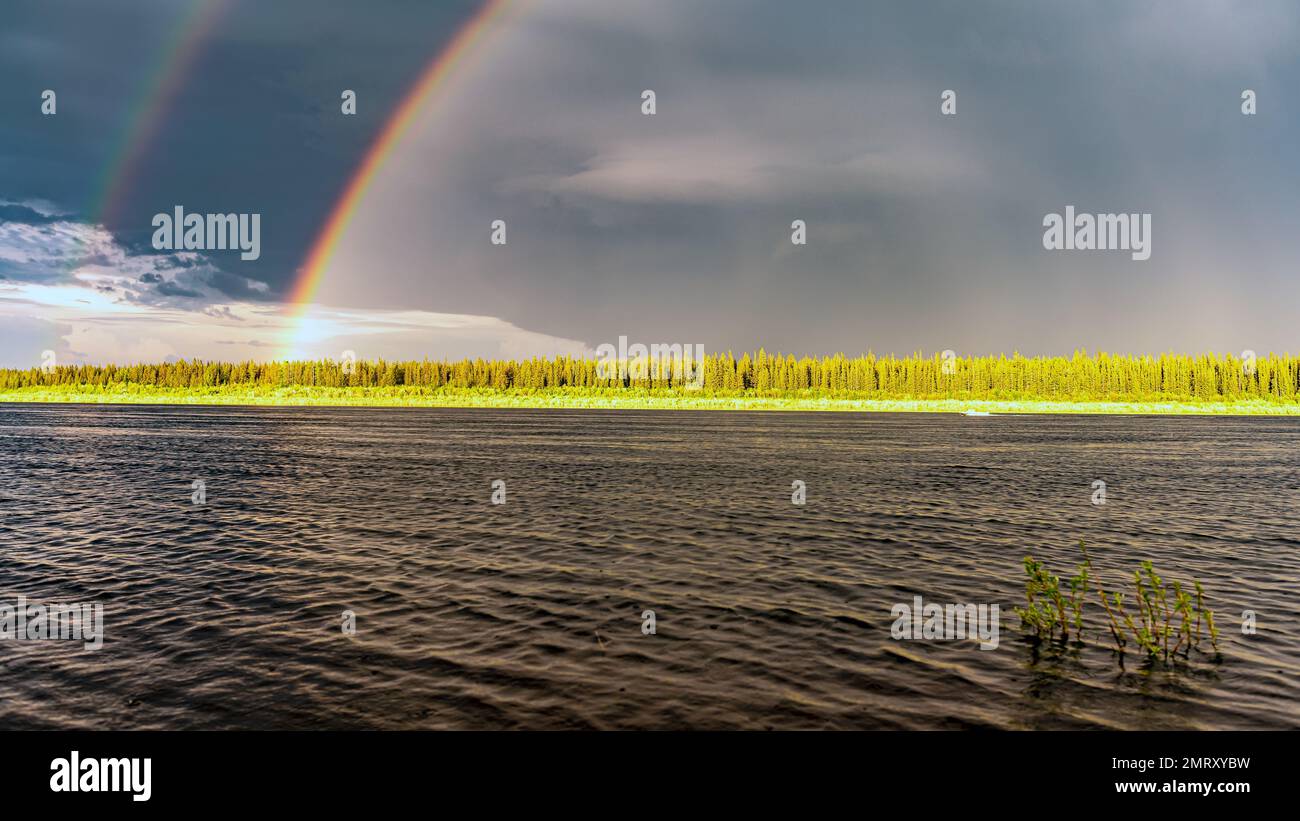 A double rainbow over the Vilyui River after rain against a blue sky ...