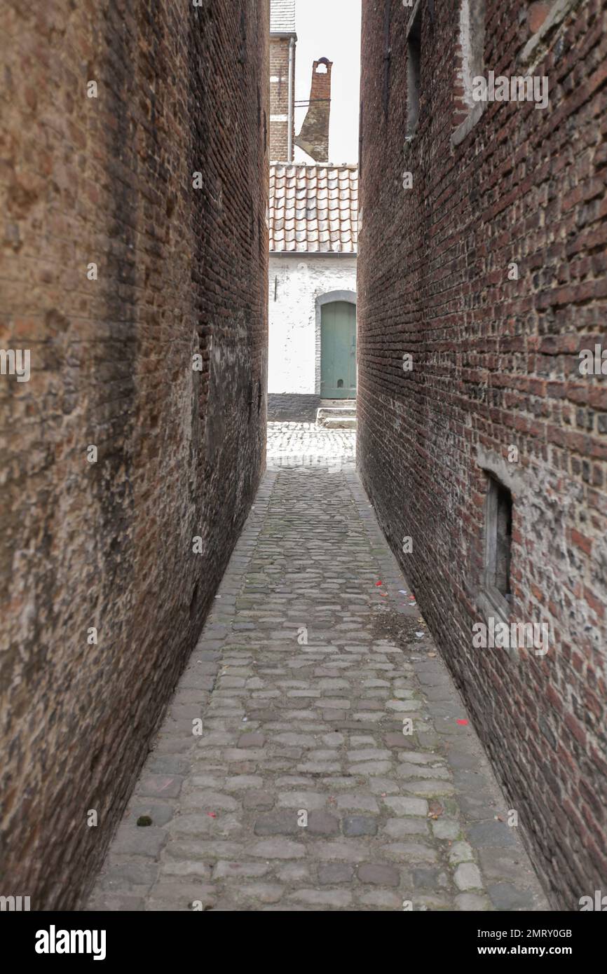 A vertical shot of a narrow alley alongside the brick buildings with ...