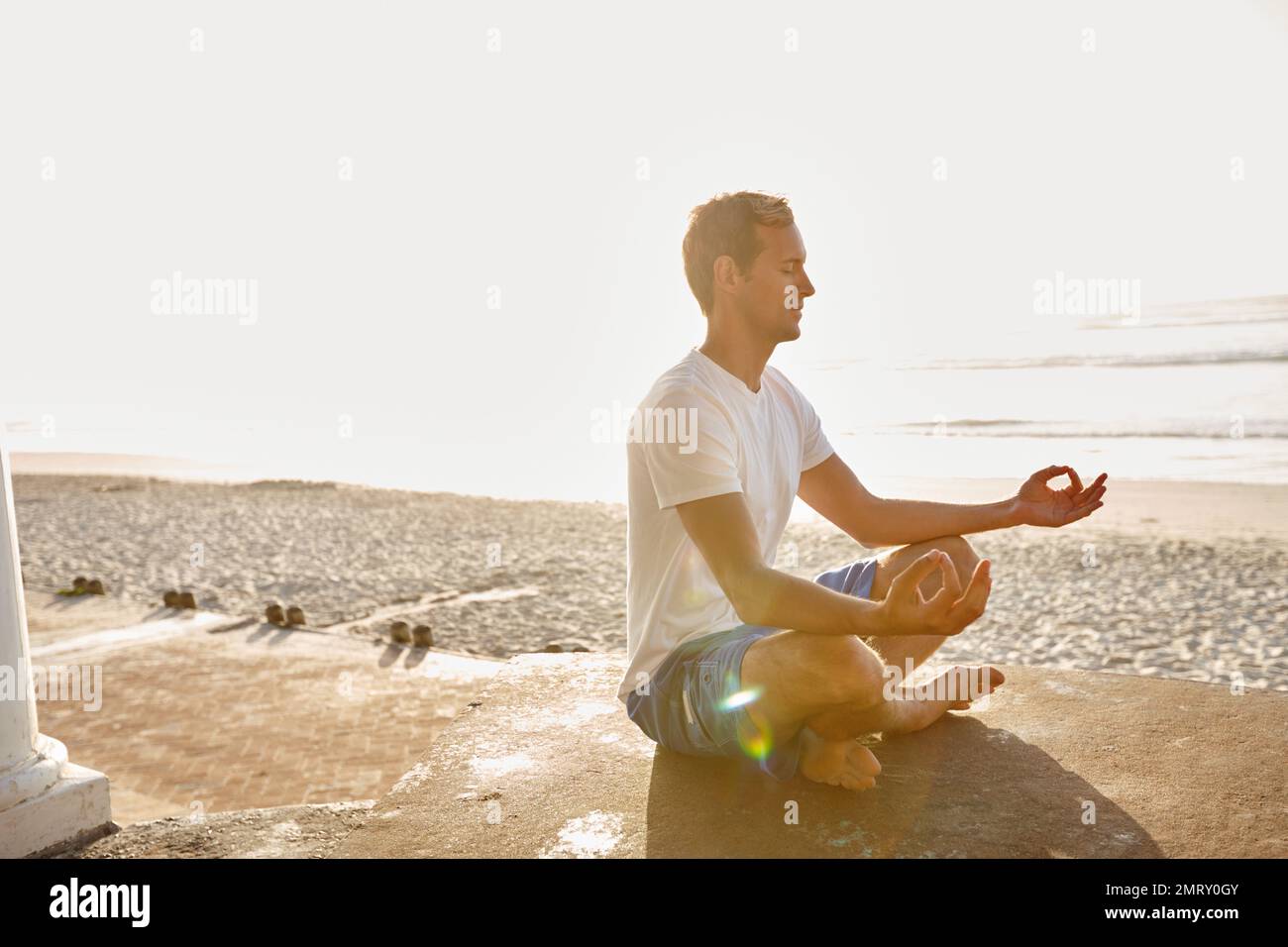 Getting in touch with his spiritual side. a man meditating at the beach ...