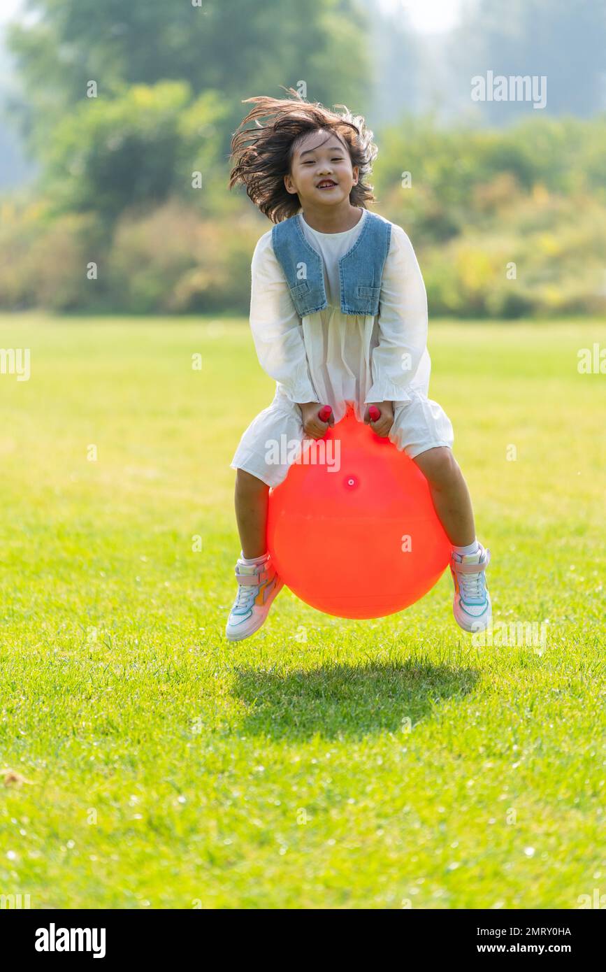 A little girl play ball on the grass Stock Photo - Alamy