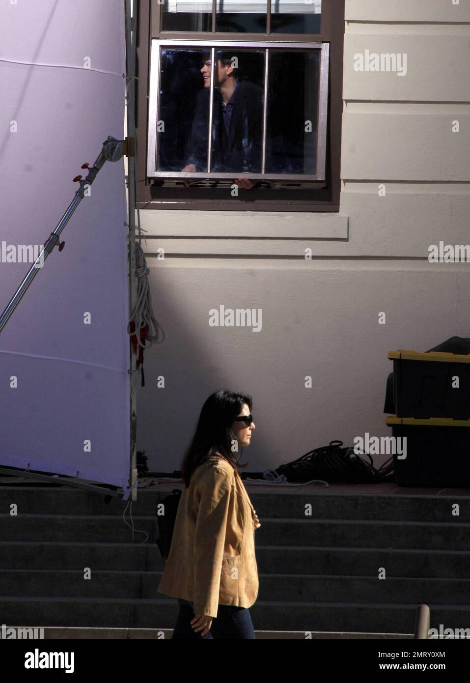 Matt Damon looks to be prying open a window while on the set of his new ...