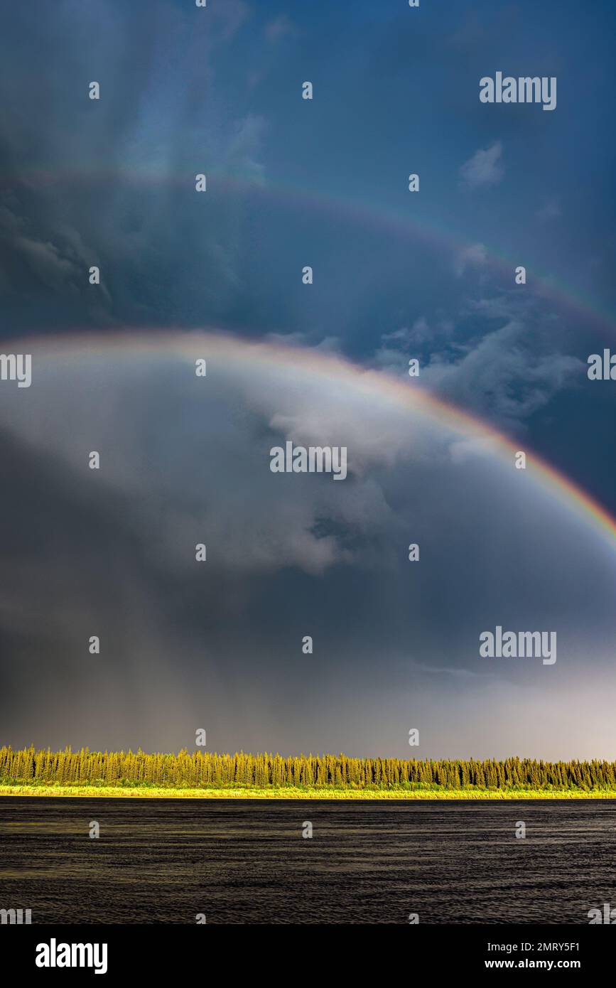 Double bright rainbow over the river Vilyui after rain against the sky ...