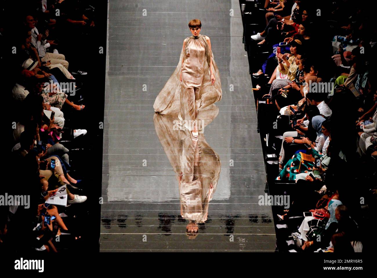 A model wears a creation from Fiziwoo which reflects on a floor as she ...