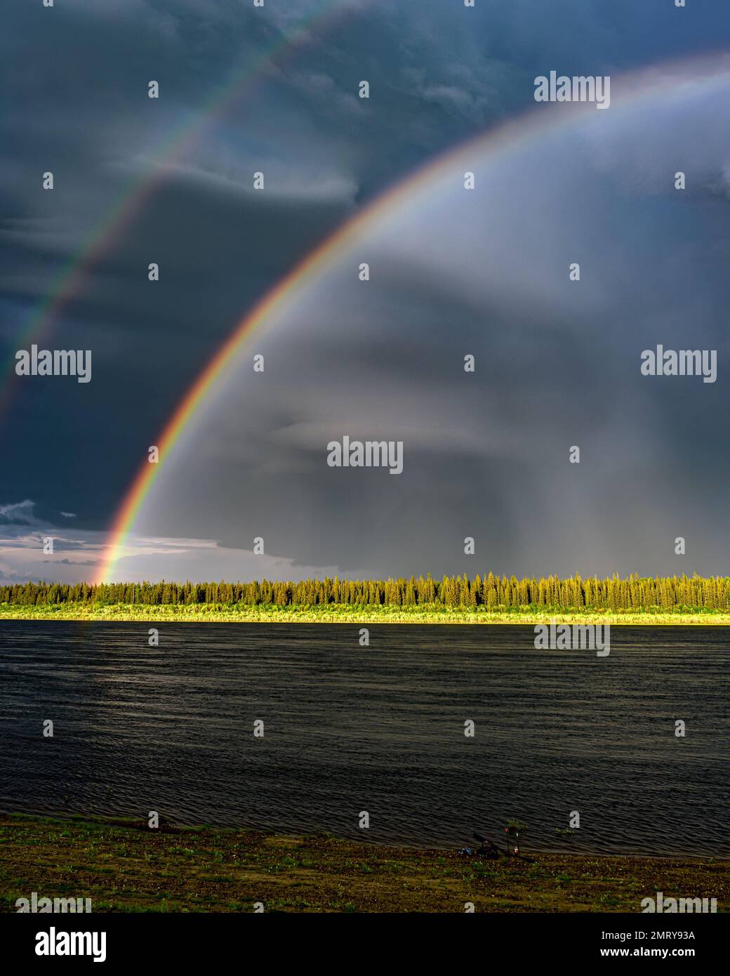 A double rainbow over the Vilyui River after rain against a dark blue ...