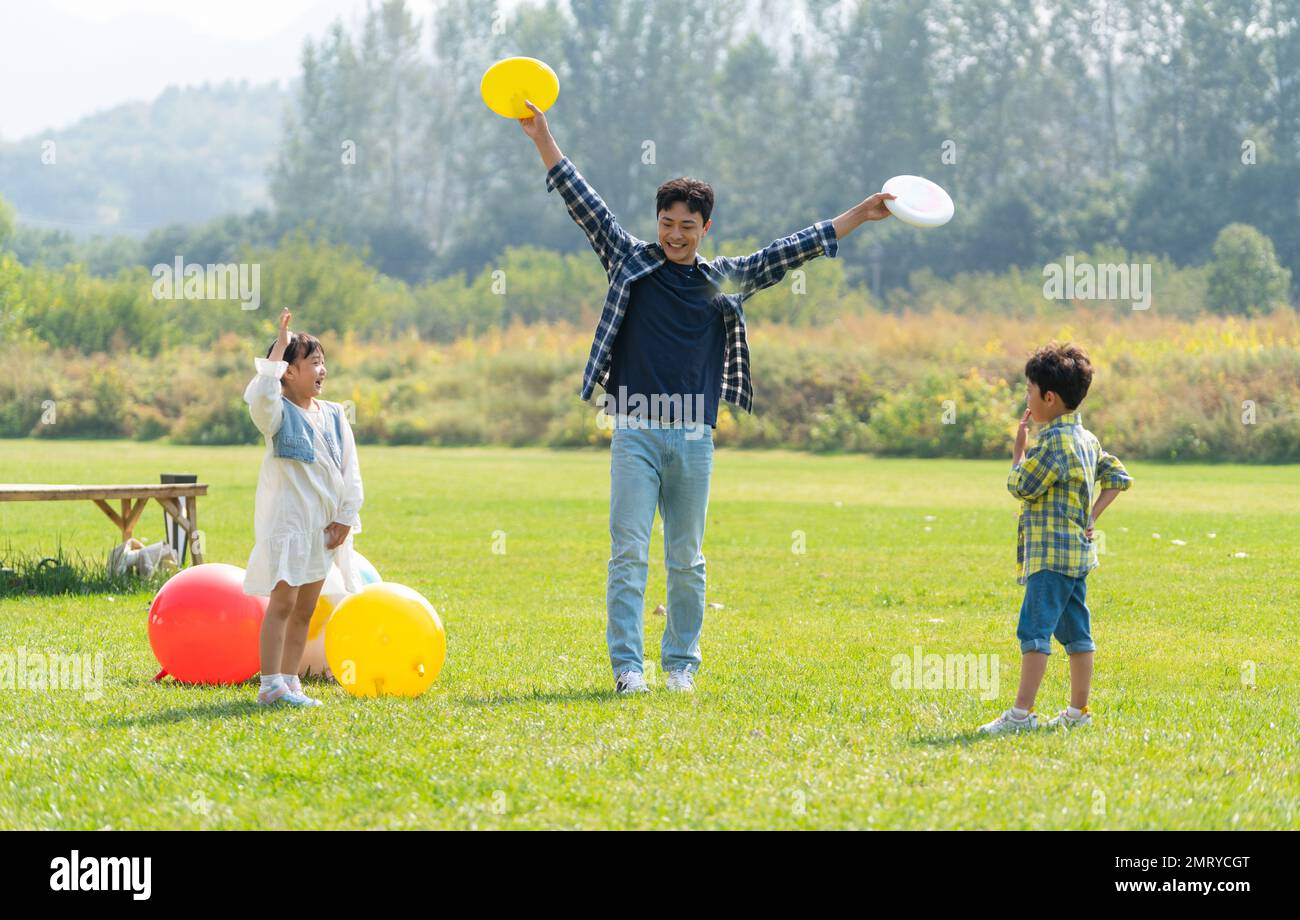 Father and child throw a frisbee on the lawn Stock Photo - Alamy