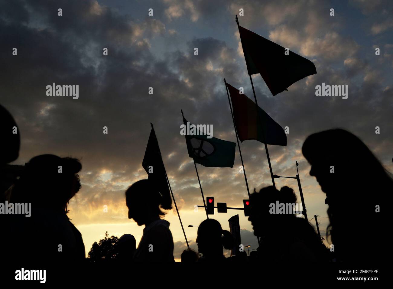 Protesters, silhouetted against the evening sky, demonstrate in ...