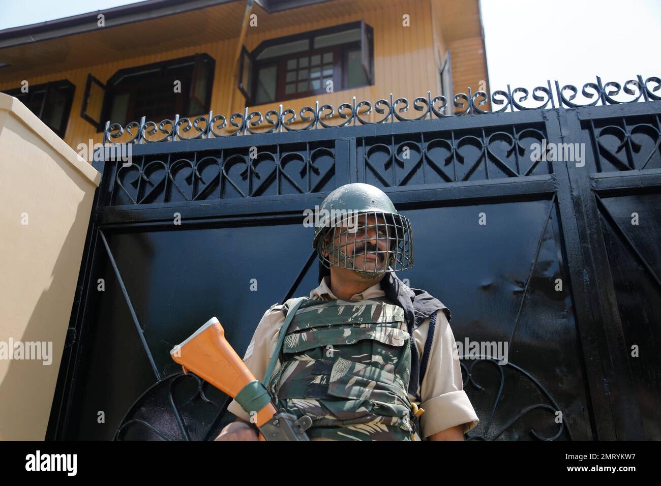 An Indian paramilitary soldier stands guard outside the house of a ...