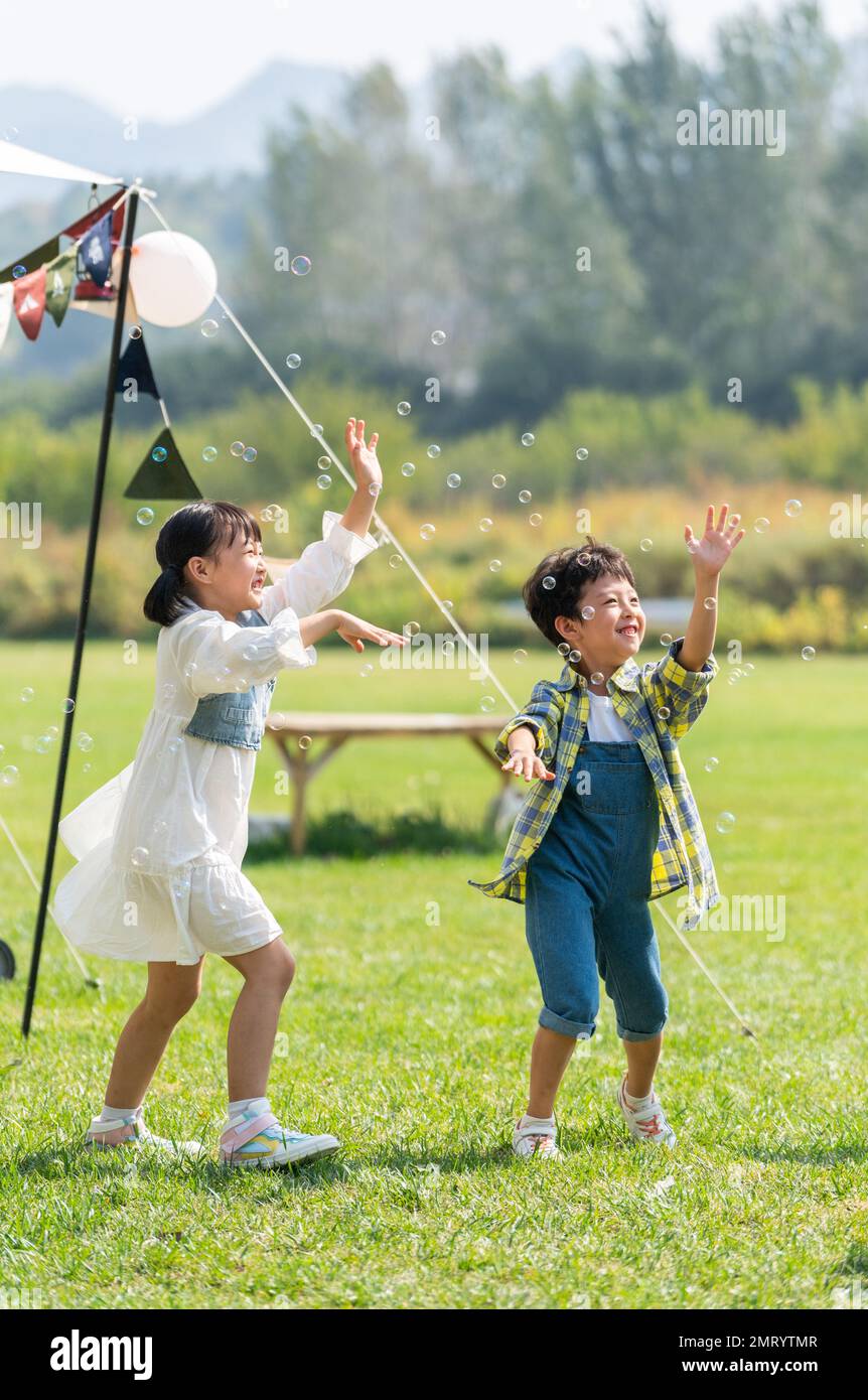 Two children playing on the grass Stock Photo - Alamy